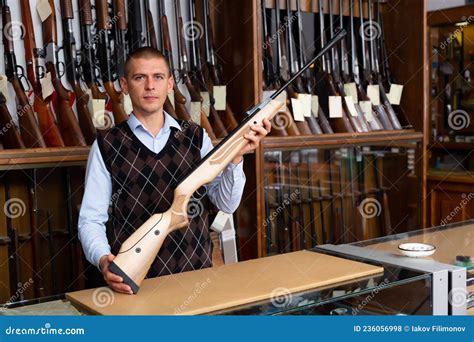 Dono Da Loja De Armas Mostrando Espingarda De Ar De Quebra cabeça