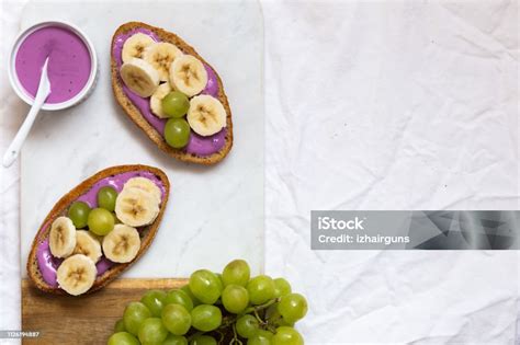 흰색 배경 평면도에 포도와 소박한 절단 보드에 바나나와 요구르트 디저트 샌드위치 빵 플랫이 하다 맛 있는 아침 식사 또는 간식