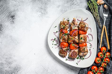 토마토와 후추를 곁들인 꼬치에 돼지고기 케밥 피크닉을위한 음식 회색 배경 맨 위 보기입니다 복사 공간 고기에 대한 스톡 사진 및