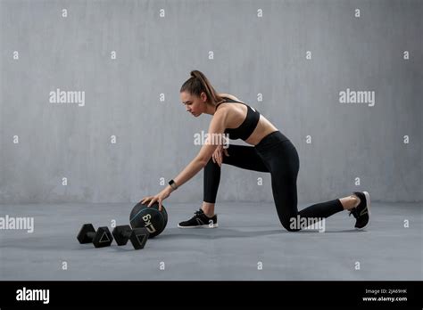 Young Athletic Woman In Sportswear Doing Squat Using Dumbbells Posing