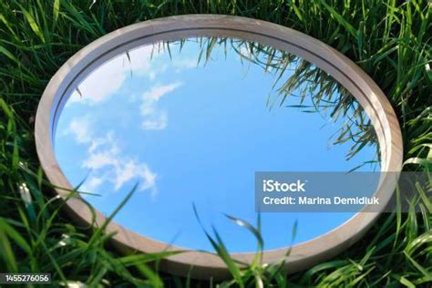 푸른 잔디가 있는 여름 들판의 둥근 나무 거울에 흐린 푸른 하늘 반사 자연 개념입니다 지구의 날 환경을 저장합니다 평화 생태 보호 기후변화 지구온난화 영향 문제 0명에 대한