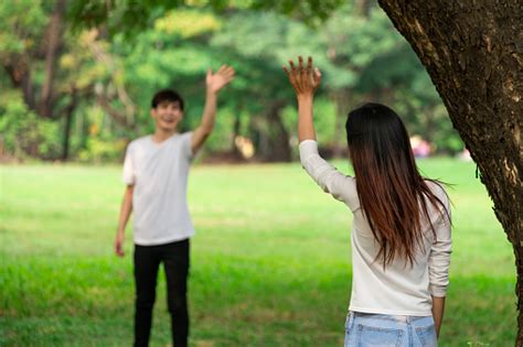 젊은 이 남자와 여자는 공원에서 손을 흔들어 인사하거나 작별 인사를합니다 2명에 대한 스톡 사진 및 기타 이미지 2명 교육