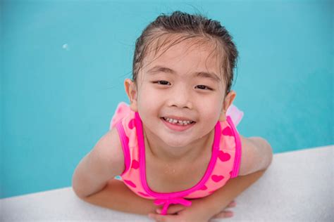 유아 소녀 키드는 야외 호텔 수영장에서 푸른 물에 분홍색 수영복으로 수영장 여름철에 장난스럽게 수영합니다 행복한 소녀는 여름