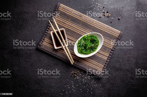 일본과 중국 요리 개념입니다 華 샐러드 해 초 참 깨 올리브유와 향신료에서 이루어집니다 간장 소스와 검은색에 중국 막대기 평면도