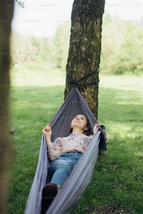 여름 공원에서 피크닉을 할 때 나무 사이에서 해먹에서 휴식을 취하고 차가워지는 젊은 여성 사회적 거리 두기 솔로 야외 활동 뉴노멀 안전 모임의 레저 사진