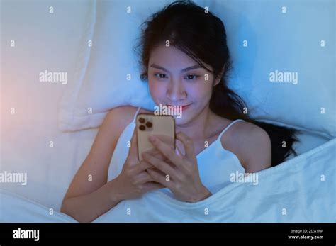 Beautiful Young Asian Woman Is Using Smartphone To Text While Getting