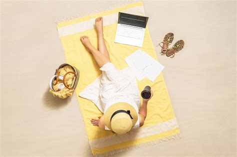 사업가 프리랜서는 모래 해변의 비치 타월에 앉아 그래픽과 차트와 노트북에서 작업 커피를 마시고 여름 방학 공중 보기 일함에 대한