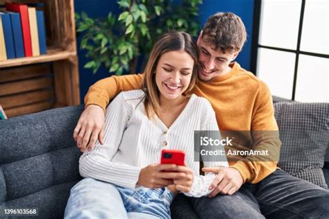 집에서 소파에 앉아있는 스마트 폰을 사용하는 젊은 남녀 부부 가정 생활에 대한 스톡 사진 및 기타 이미지 가정 생활 청년 성인 2명 Istock
