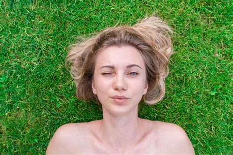 Close Up Of Beautiful Young Woman Lying Down In The Green Grass