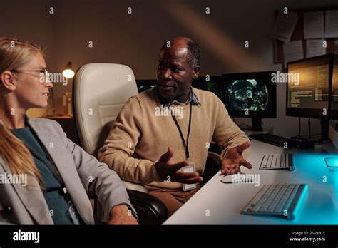 Confident Male Programmer Explaining Ways Of Decoding Data To Blond
