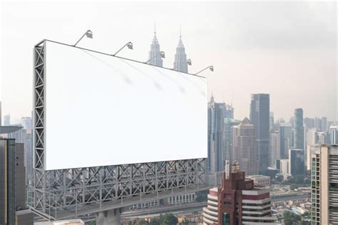 낮 시간에 Kl 도시 경관을 배경으로 하는 빈 흰색 도로 광고판 거리 광고 포스터는 3d 렌더링을 조롱합니다 사이드 뷰는