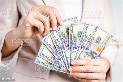 흰색 배경에 돈 우리에게 달러 지폐를 제안 하는 비즈니스 여자 손의 클로즈업 돈 개념 100 달러 지폐 미국 지폐 통화에 대한