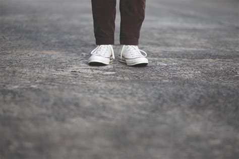 닫 다 다리 남자 서 있는도로 콘크리트 바닥 야외 입고 세련 된 청바지 바지 코 듀로이 브라운과 운동 화 신발 메시지를 쓰기 위해 빈 복사 공간을 비워 두십시오 거리에 대한