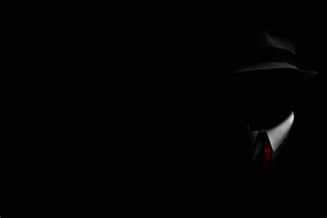 Download Sophisticated Man Working On A Black Mac Wallpaper