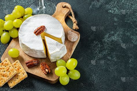 在木盘上品尝奶酪的菜肴美酒佳肴浪漫约会黑色混凝土背景下的奶酪熟食顶部视图与复制空间