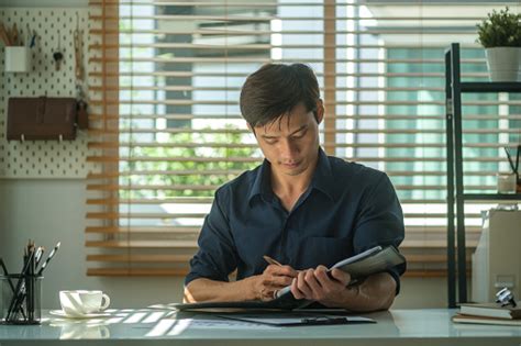 밀레니얼 세대의 사업가가 현대 직장에 앉아 근무 일정 계획을 확인하고 있다 학습에 대한 스톡 사진 및 기타 이미지 학습 태블릿 비즈니스 Istock