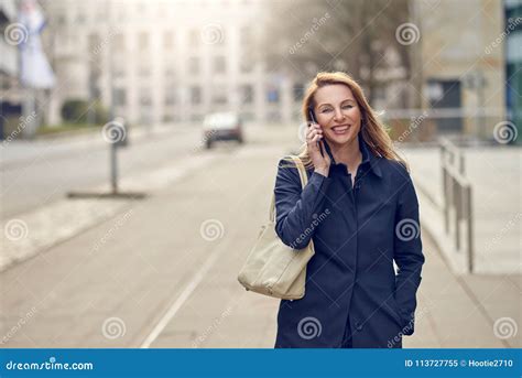 Attractive Stylish Blond Woman Chatting On Her Smartphone Stock Image