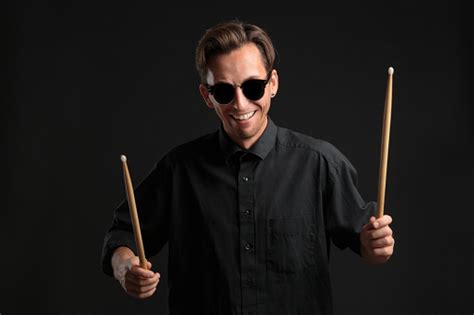 검은 셔츠와 어두운 배경에 막대기로 드럼을 연주 하는 선글라스와 선글라스에 세련 된 남자 드러머 거친에 대한 스톡 사진 및 기타 이미지 Istock