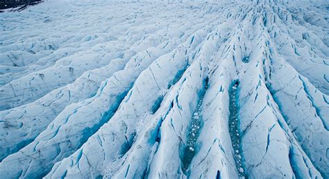 Aerial View Of A Glacier With Deep Crevasses And Ice Blue Streaks