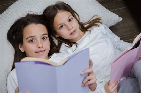 Free Photo Sisters Reading Book Together