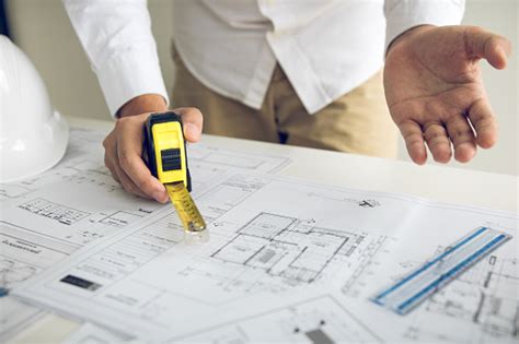 설계자는 청사진을 작업하고 사무실에서 회의에서 함께 프로젝트를 논의합니다 가리키기에 대한 스톡 사진 및 기타 이미지 가리키기 건설 기계류 건설 산업 Istock