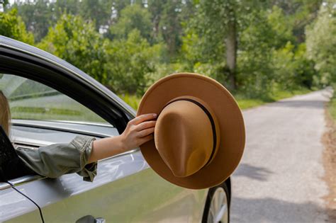 창문 밖에서 손에 모자를 들고 차를 타고 있는 여자 현지 여행 컨셉 자유와 자연과의 교감 주말에 즐기는 지속 가능한 라이프스타일