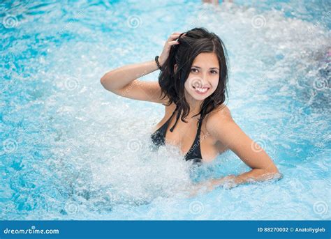 Giovane Donna Castana In Un Costume Da Bagno Nero Con Un Sorriso Bianco