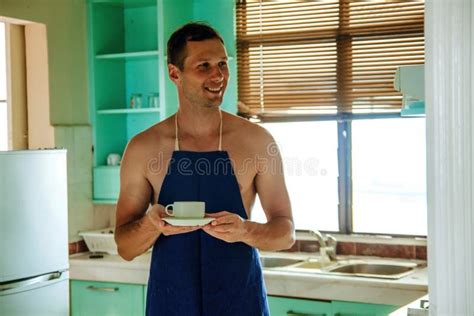 Muscular Topless Man In Apron Making Coffee For Breakfast In Kitchen