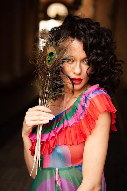Premium Photo A Woman With A Feather In Her Hand Is Holding A Peacock