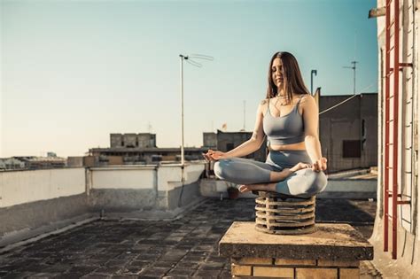 Premium Photo Relaxed Woman Practicing Yoga Meditating On A Rooftop
