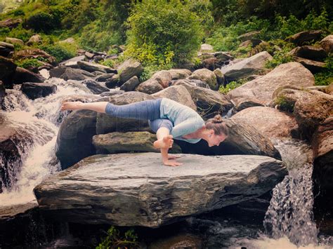 1高清图片 做瑜伽asana Eka Pada Koundinyasana 1的年轻运动的适合妇女在热带瀑布葡萄酒减速火箭的作用过滤了行家样式