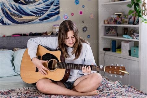 Image Of Teen Girl Playing Guitar In Her Bedroom Austockphoto