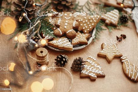 빈티지 접시와 아니스 계피 소나무 콘 소박한 테이블에 황금 빛삼나무 가지에 크리스마스 진저 브레드 쿠키 구운 전통 진저 브레드 남자 나무 스타 쿠키 0명에 대한 스톡 사진