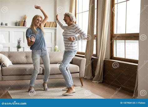 Äldre Mor Och Millenniumdotter Som Dansar Tillsammans I Vardagsrummet
