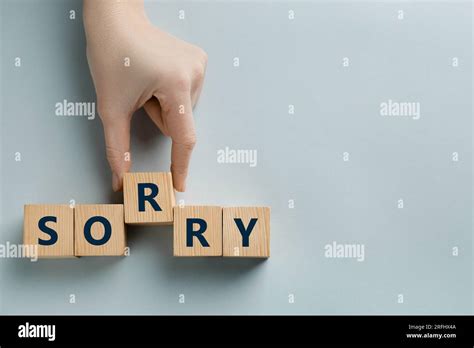 Woman Adding Cube With Letter R To Make Word Sorry On Light Background