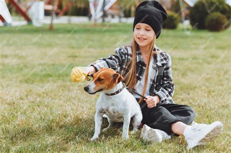 Uma Garotinha Está Brincando Com Seu Cachorro Na Grama No Parque Jack