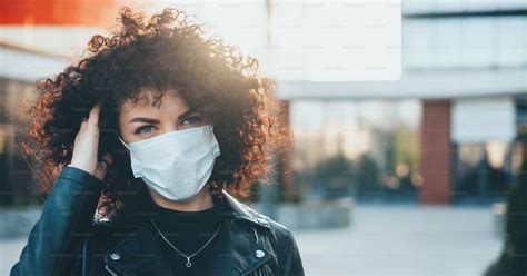 곱슬 머리와 검은 가죽 재킷을 입은 젊은 백인 여성이 보호 마스크를 쓰고 있다 사진 Unsplash의 초상 이미지