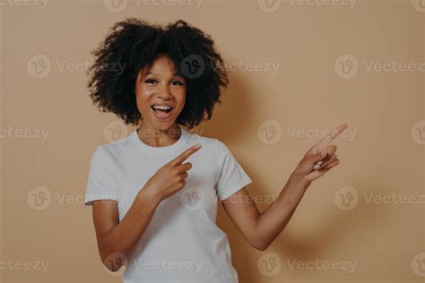 Young African American Girl Cheerfully Smiling And Pointing With Index