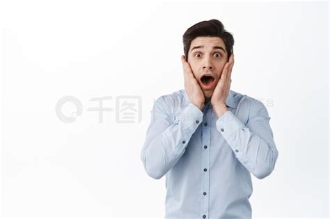 背景高清图片 震惊而震惊的白人男子喘着粗气双手放在脸颊上无言地盯着镜头敬畏地站在白色背景下 商务办公免费下载 jpg格式 编号