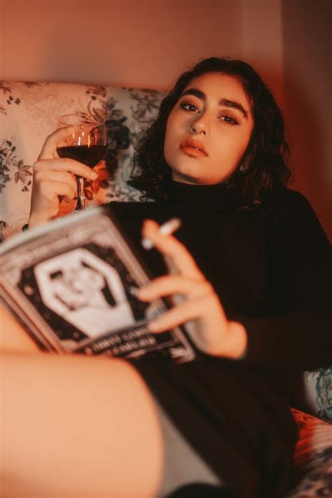 Woman Smoking While Sitting In Armchair With Book And Wine Glass · Free