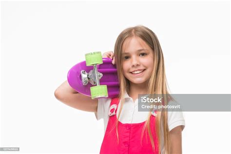 긴판으로 웃고 있는 어린이 스케이팅 선수 스케이터 소녀로 태어났다 어린 소녀는 흰색에 고립 된 스케이트 보드와 미소 긴 머리를 가진 스케이트 보드 아이 스포츠 활동과 에너지