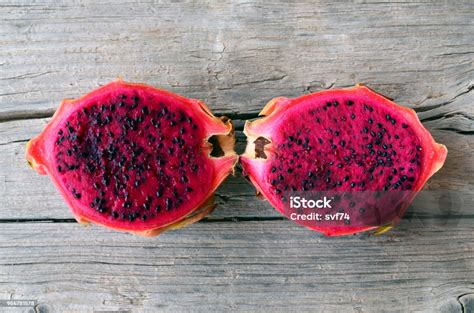 이국적인 익은 핑크 Pitaya 또는 드래곤 과일 닫습니다 Pitahaya 붉은 열 대 과일은 오래 된 나무 테이블에 반으로