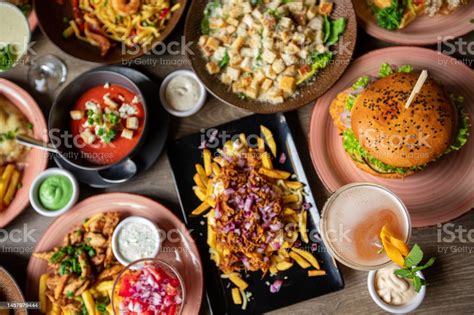 접시 평면도에 맛있는 음식으로 가득한 테이블 감자 튀김 수프 샐러드 버거 소스 및 음료는 이벤트 축하를위한 축제 저녁 식사에
