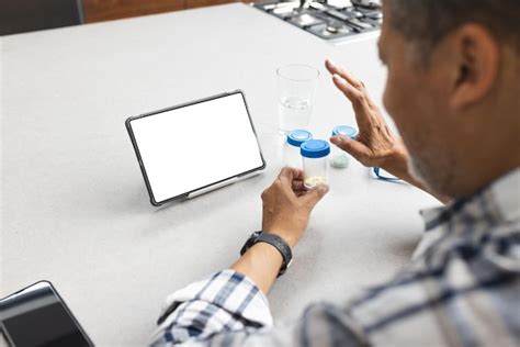 Premium Photo A Senior Man Is Examining Medication Next To A Tablet
