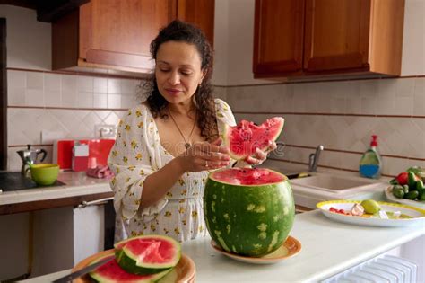African American Pretty Woman In Sundress Standing At Rustic Kitchen