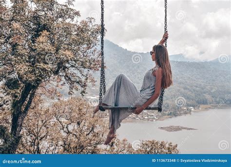 Красивая девушка с длинными темными волосами в элегантный серый представлять платья Стоковое