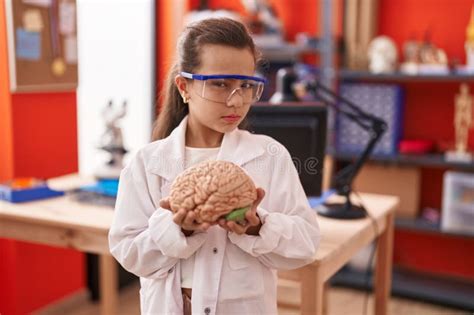 Little Hispanic Girl Holding Brain At Science Class At School Looking