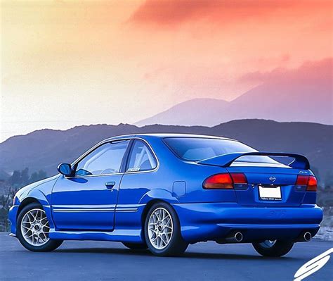 Blue Nissan B14 Parked In Front Of Mountains