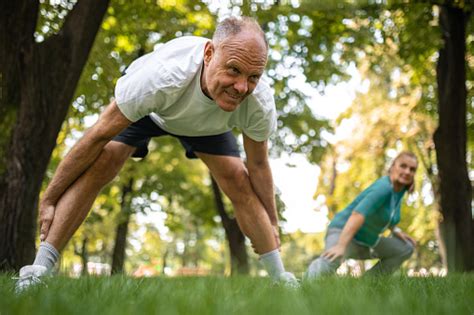 성숙한 남자 스트레칭 그의 다리와 아침 실행에 대 한 워밍업 그의 아내와 함께 공공 공원에서 2명에 대한 스톡 사진 및 기타 이미지 Istock