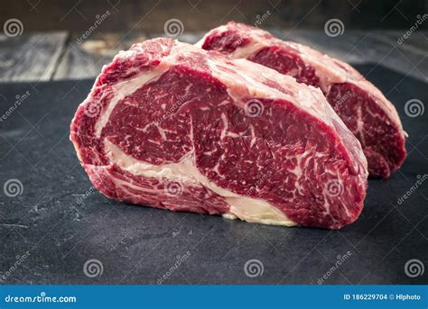 Filete De Kobe Entrecote Seco Y Seco En Bruto Ofrecido En Una Pizarra Negra Foto De Archivo